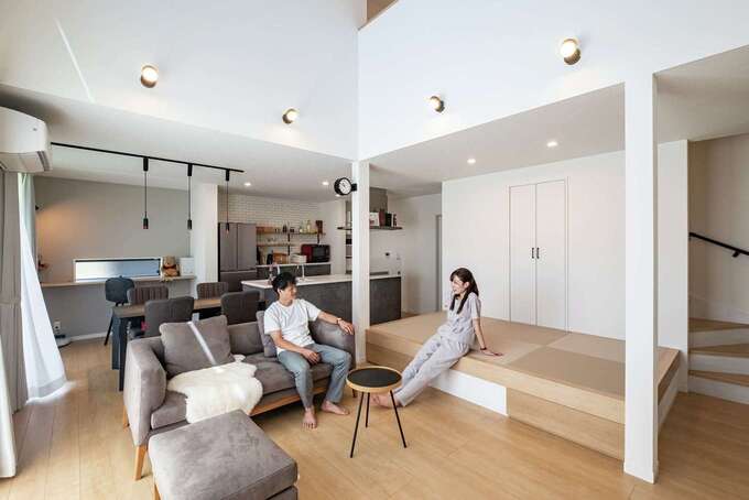 24畳のLDK。リビングに大きな吹抜けを採用。リビングとダイニングの天井高が異なることで、視覚的変化が生まれ、より開放感が生まれた。キッチン